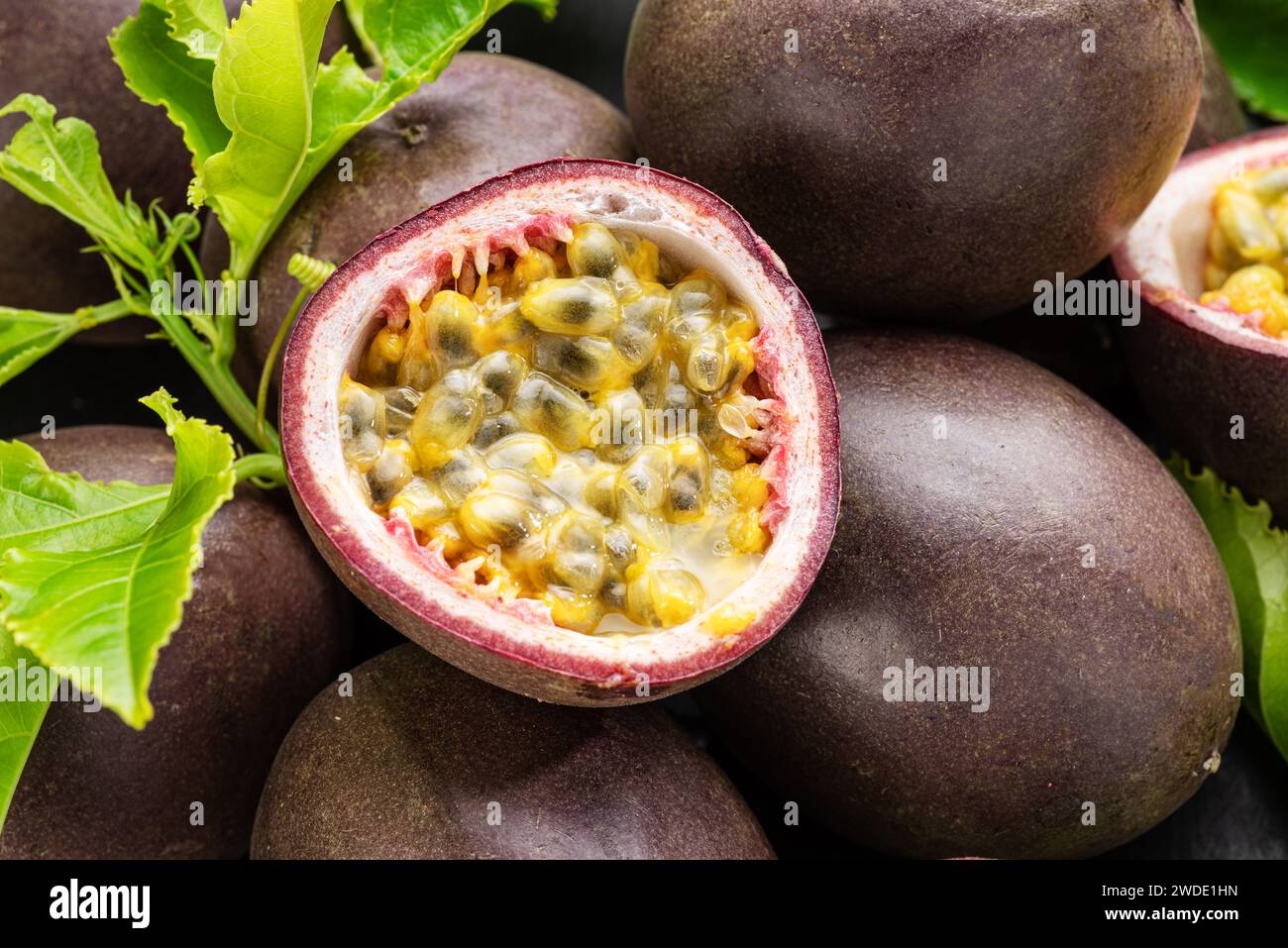 Ripe passion fruits with passion fruit seeds and passionfruit leaves on ...