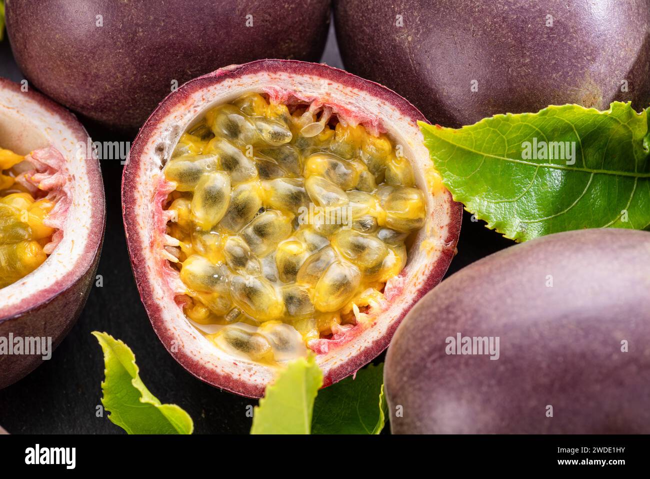 Ripe passion fruits with passion fruit seeds and passionfruit leaves on ...