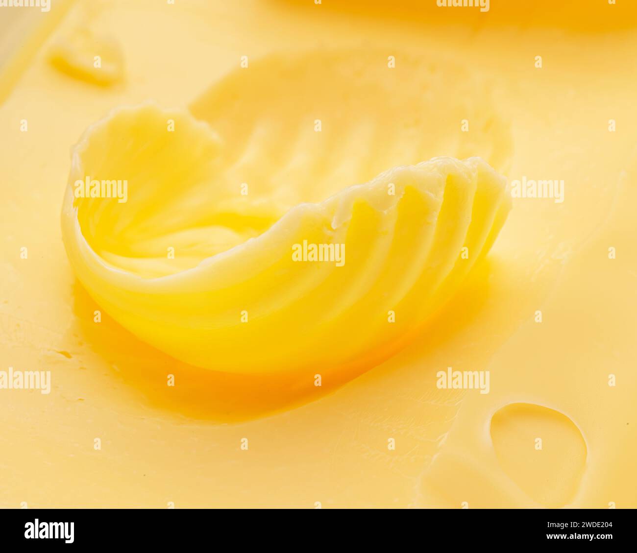 Butter curl over the piece of the butter closeup. Food background Stock ...