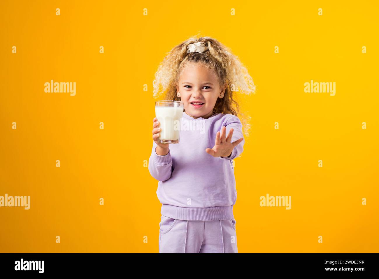 Dairy Discomfort: Expressive girl holding a glass of milk, illustrating ...