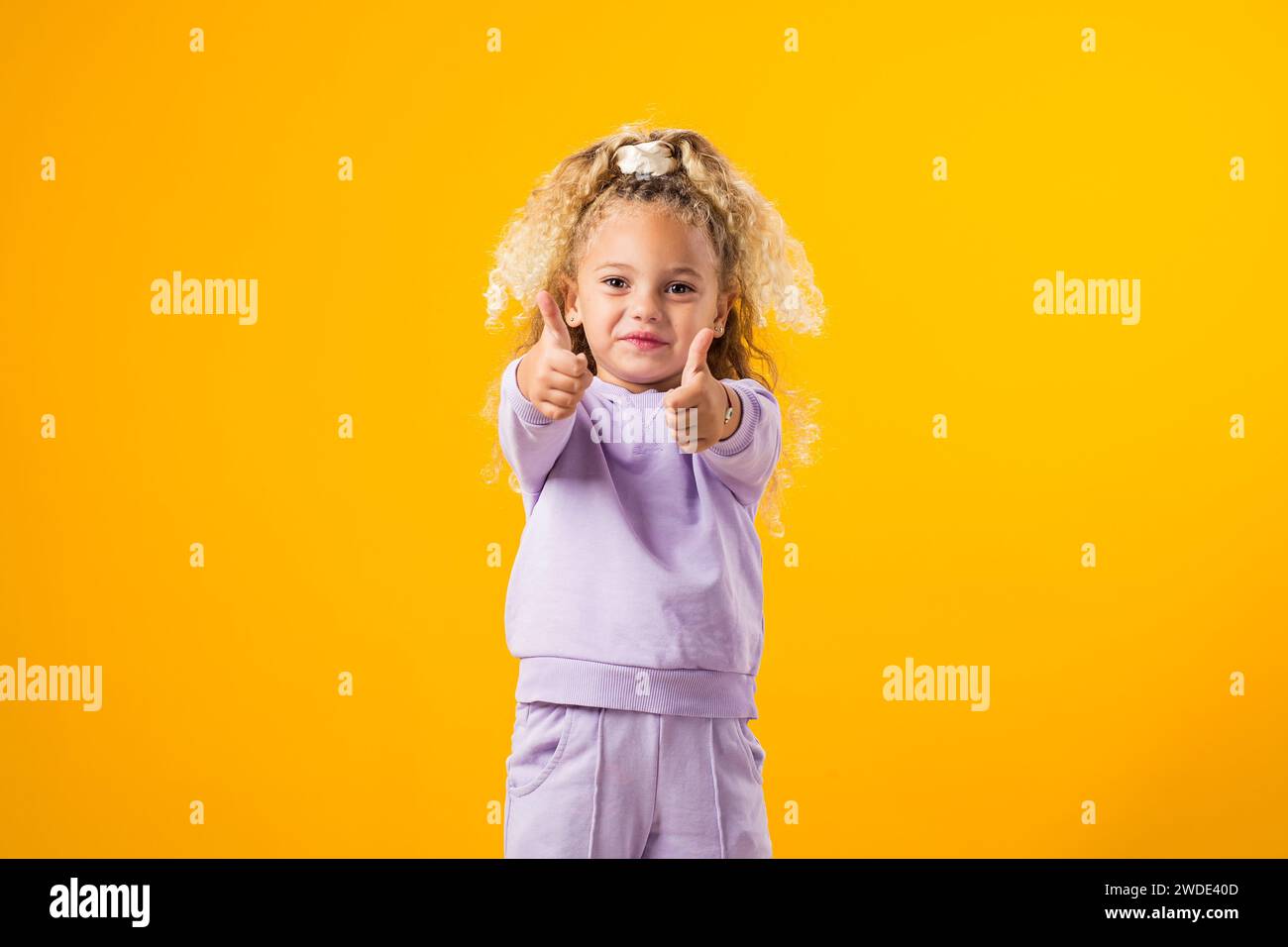 Portrait Of Child Girl Expressing Positivity with a Thumbs-Up Gesture ...