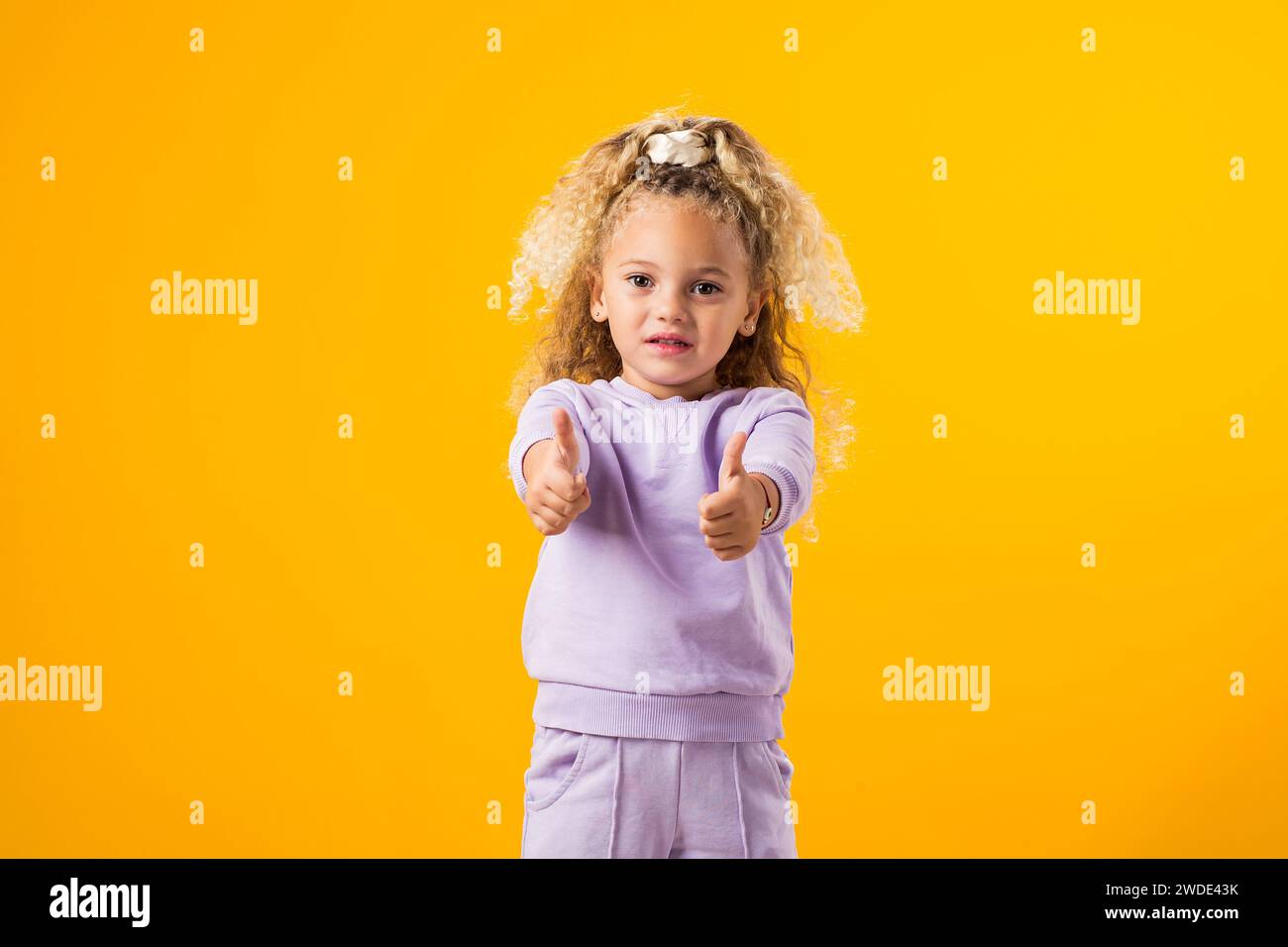 Portrait Of Child Girl Expressing Positivity with a Thumbs-Up Gesture ...