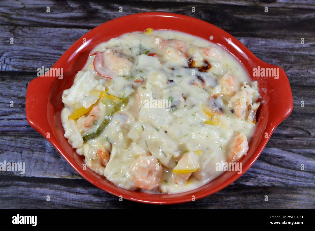 Creamy seafood casserole pot shrimps, squid calamari, fish fillet ...