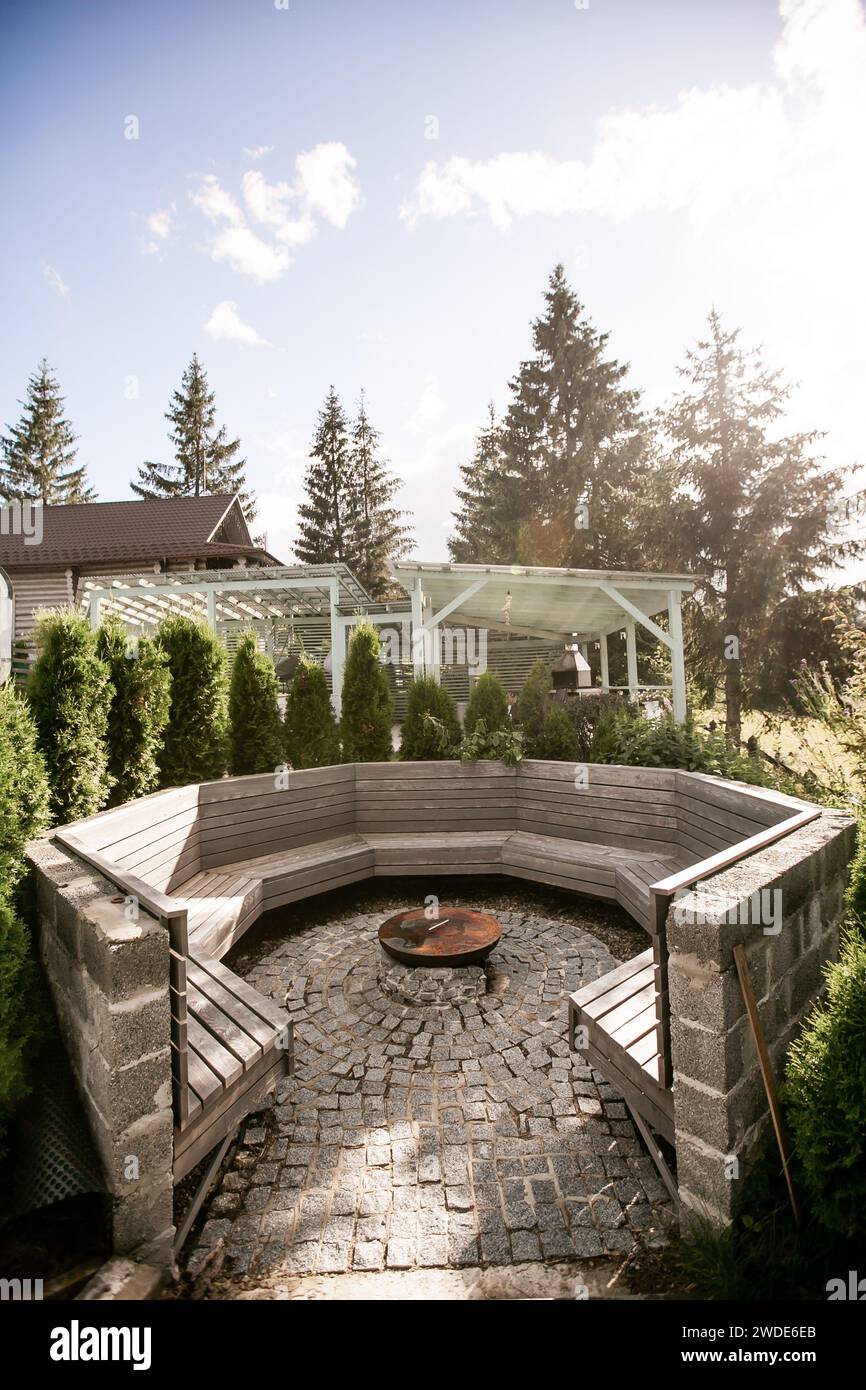 Patio made of natural stone and composite boards. Round table with a ...