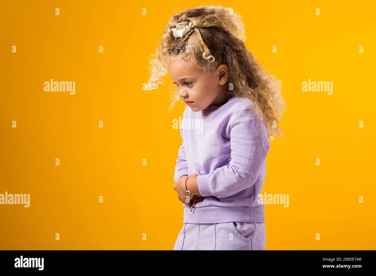 Portrait of child girl feeling abdominal pain, keeping hands on stomach ...