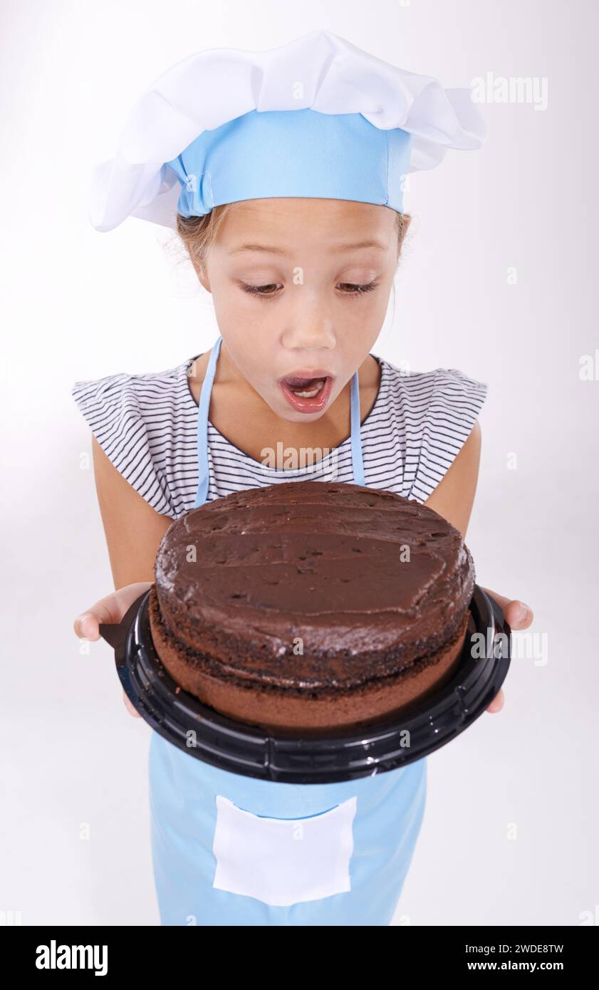 Kid, baker and shocked with cake, happy and confident with child ...