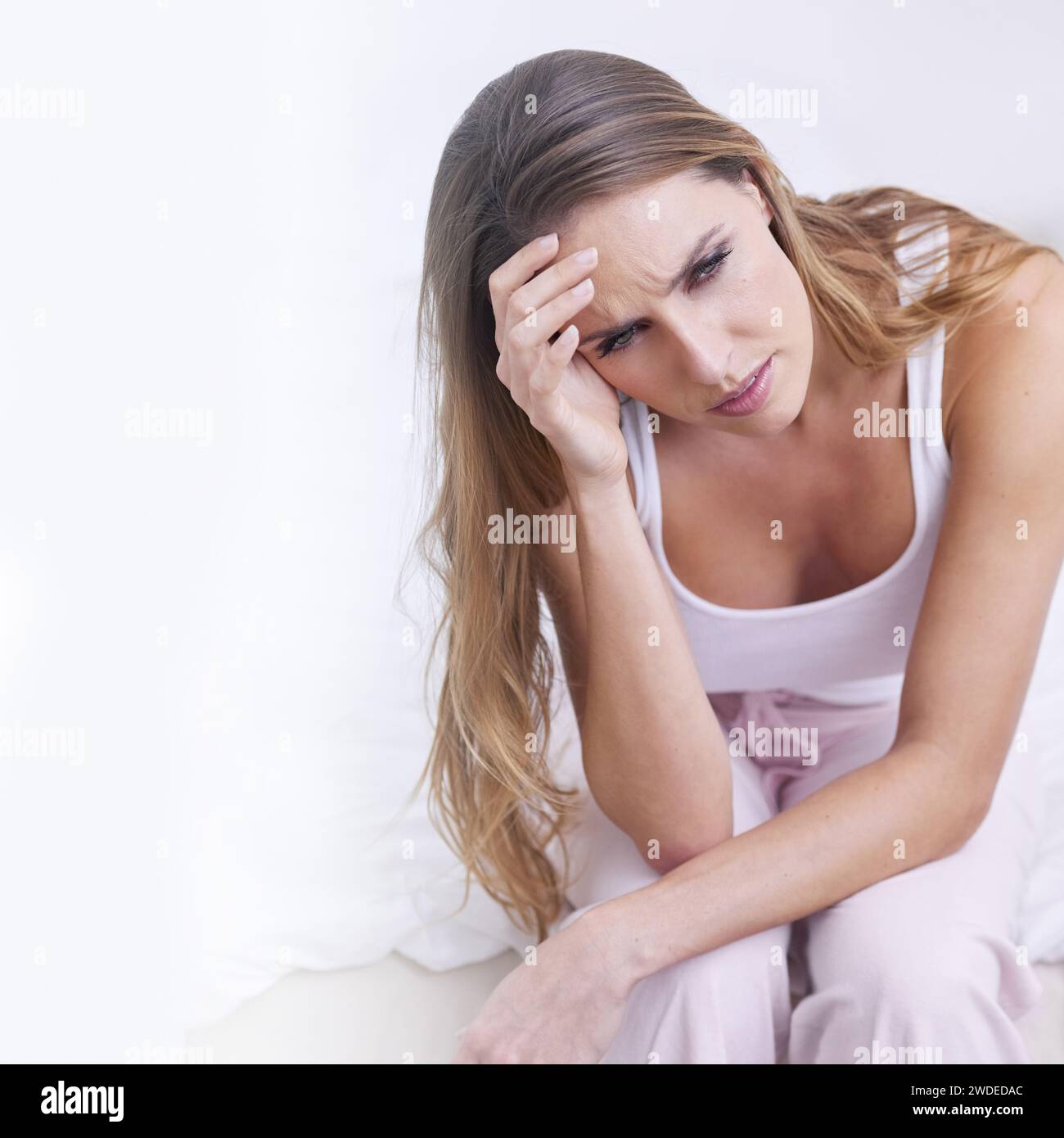 Frustrated woman, headache and stress on bed in morning, wake up or ...