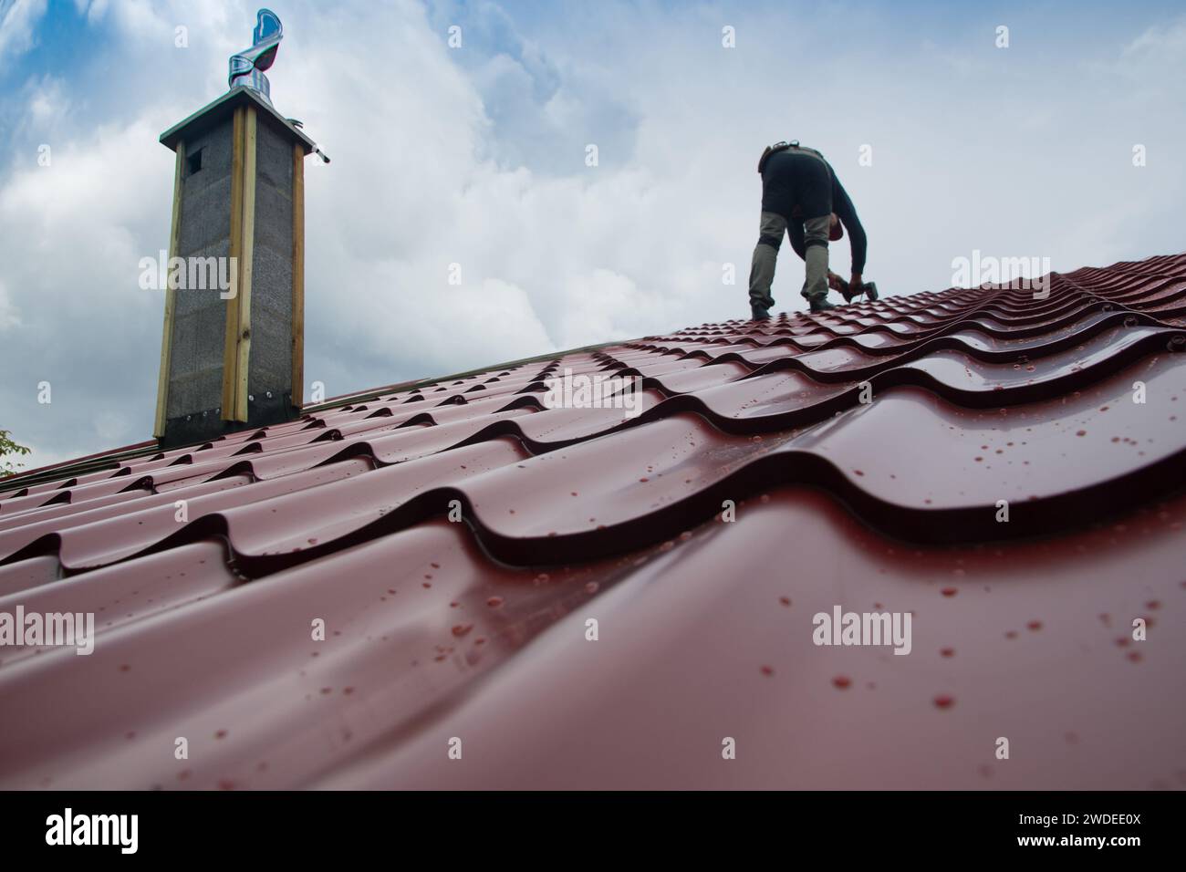 Roofer working on roof structure of building on construction site ...