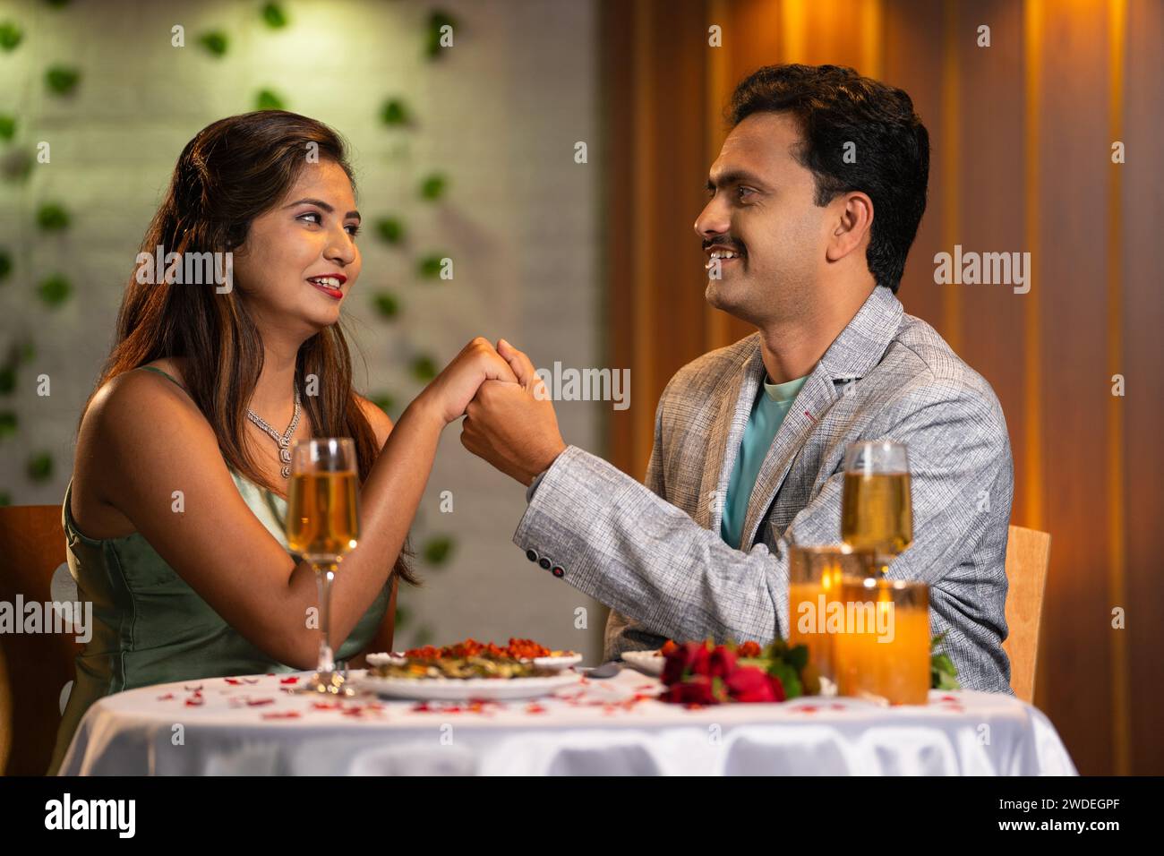 Romantic couples talking together by holding hands during candlelight ...