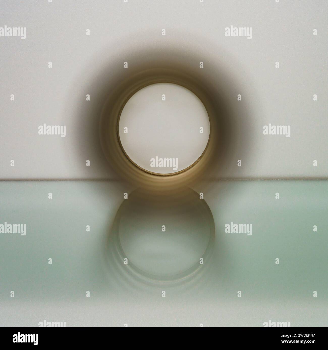 A macro view of the tubular center of a spring and its reflection lying ...
