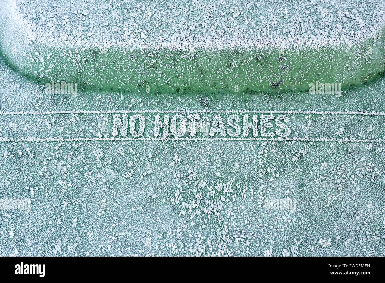 A frozen and frosty No Hot Ashes warning sign on a bin lid Stock Photo ...
