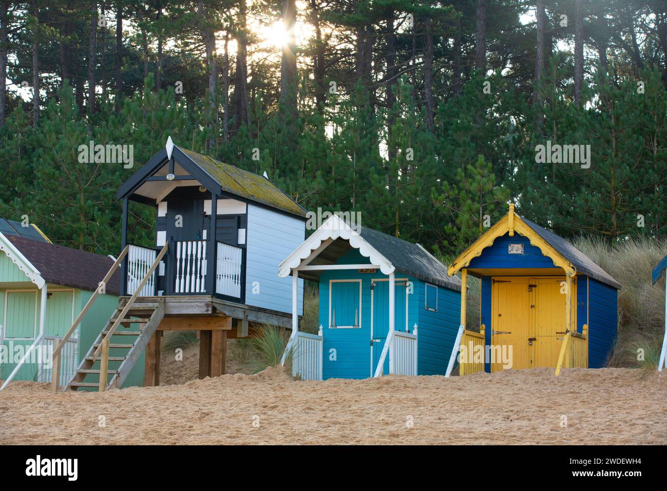 Brightly coloured wooden huts on the beach at Wells-next-the-Sea ...