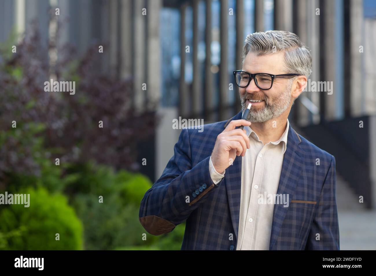 Senior professional man in business attire, looking cheerful outside a ...