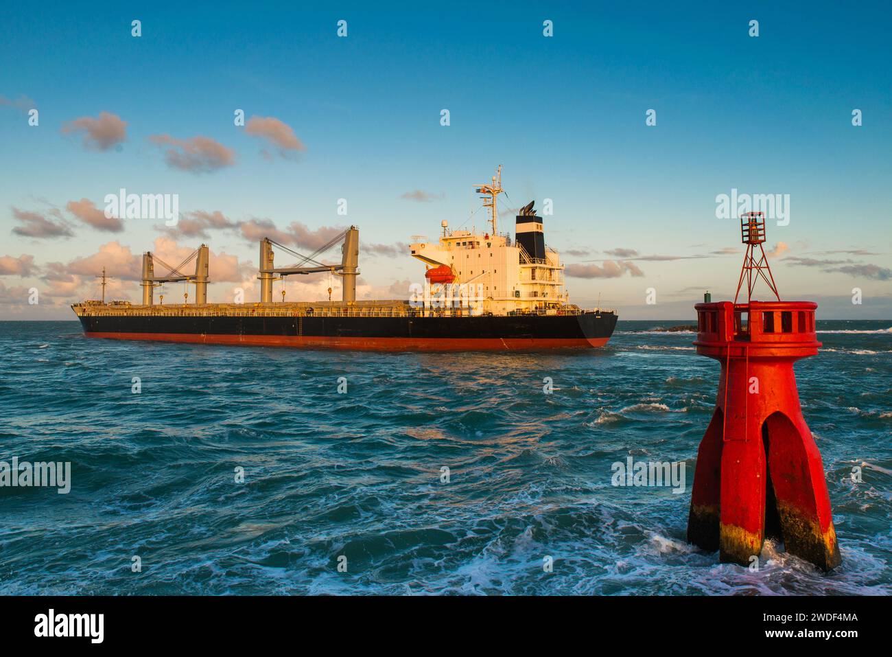 Large Cargo Ship at the Coast of Natal City and a Small Red Lighthouse ...