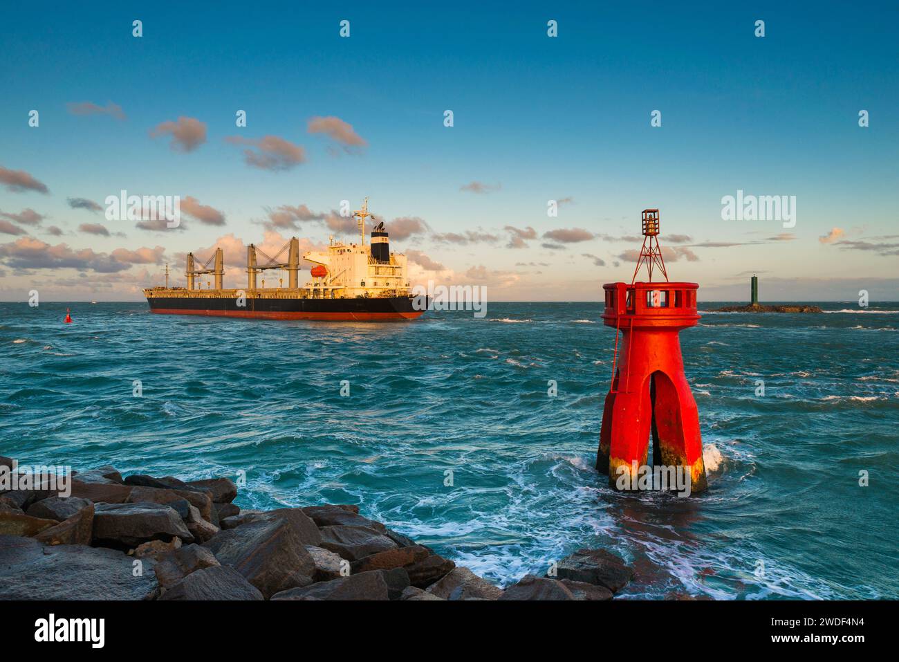 Large Cargo Ship at the Coast of Natal City and a Small Red Lighthouse ...