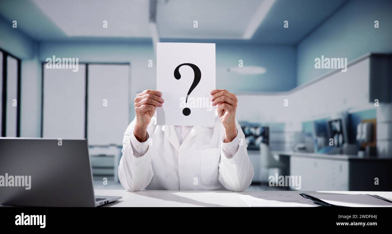 Male Doctor Holding Question Mark Sign In Front Of His Face At Hospital ...
