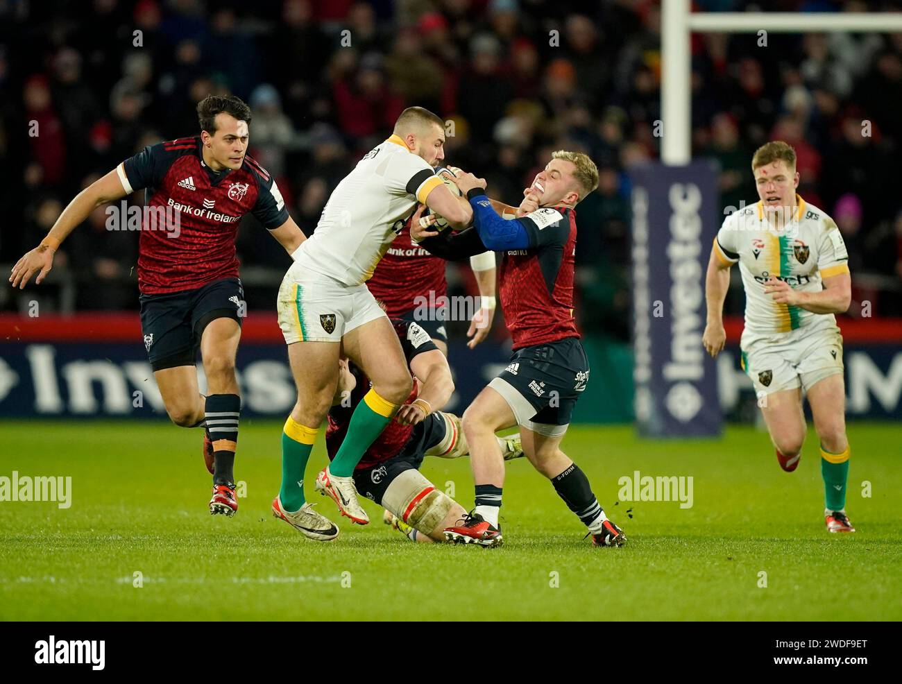 Northampton Saints' Ollie Sleightholme (left) ia tackled by Munster's ...