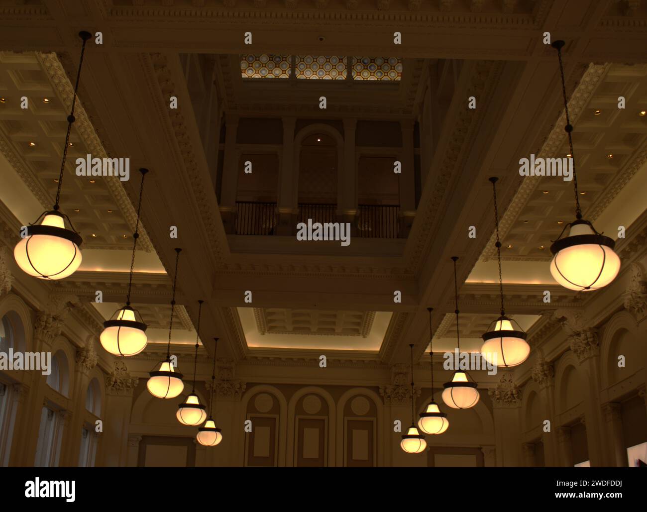 Brightly lit hallway in a spacious building adorned with numerous lamps ...