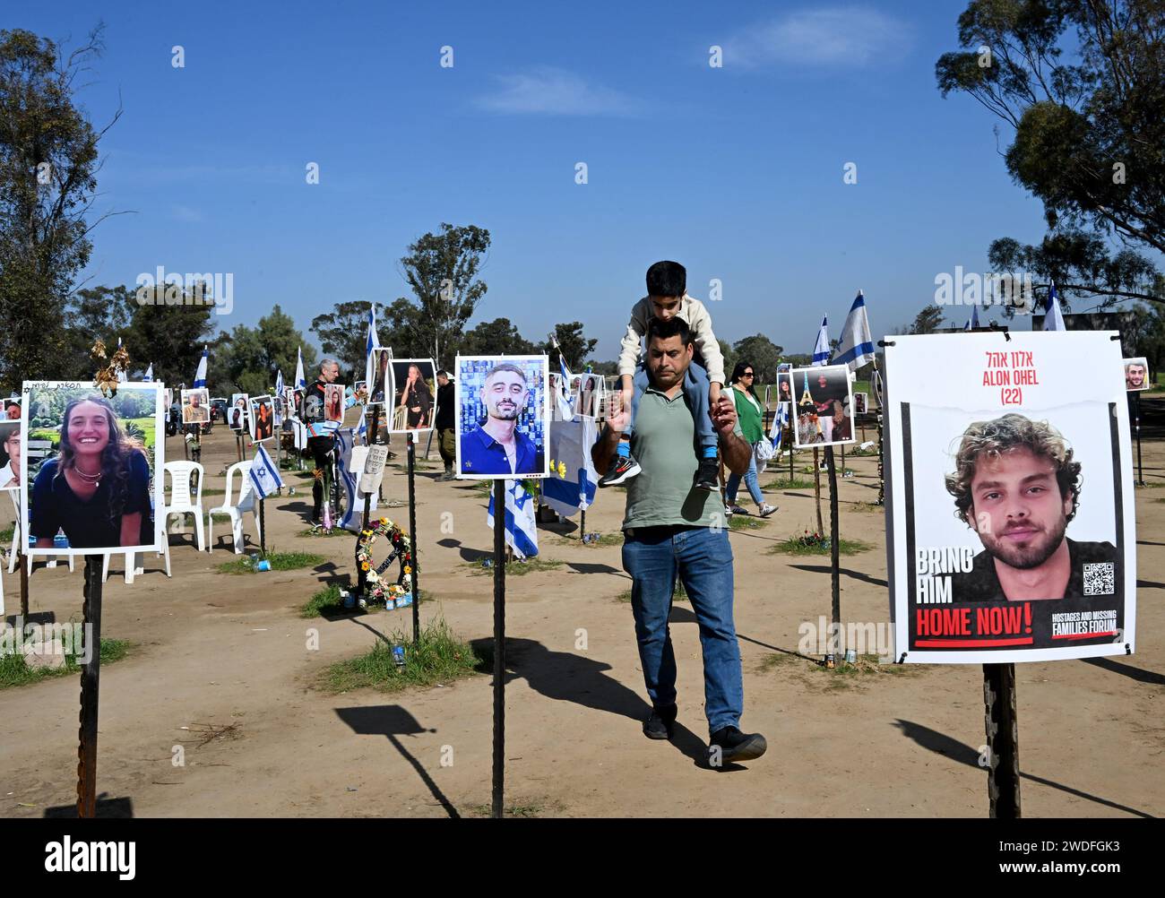 Reim, Israel. 20th Jan, 2024. People walk by national flags and ...