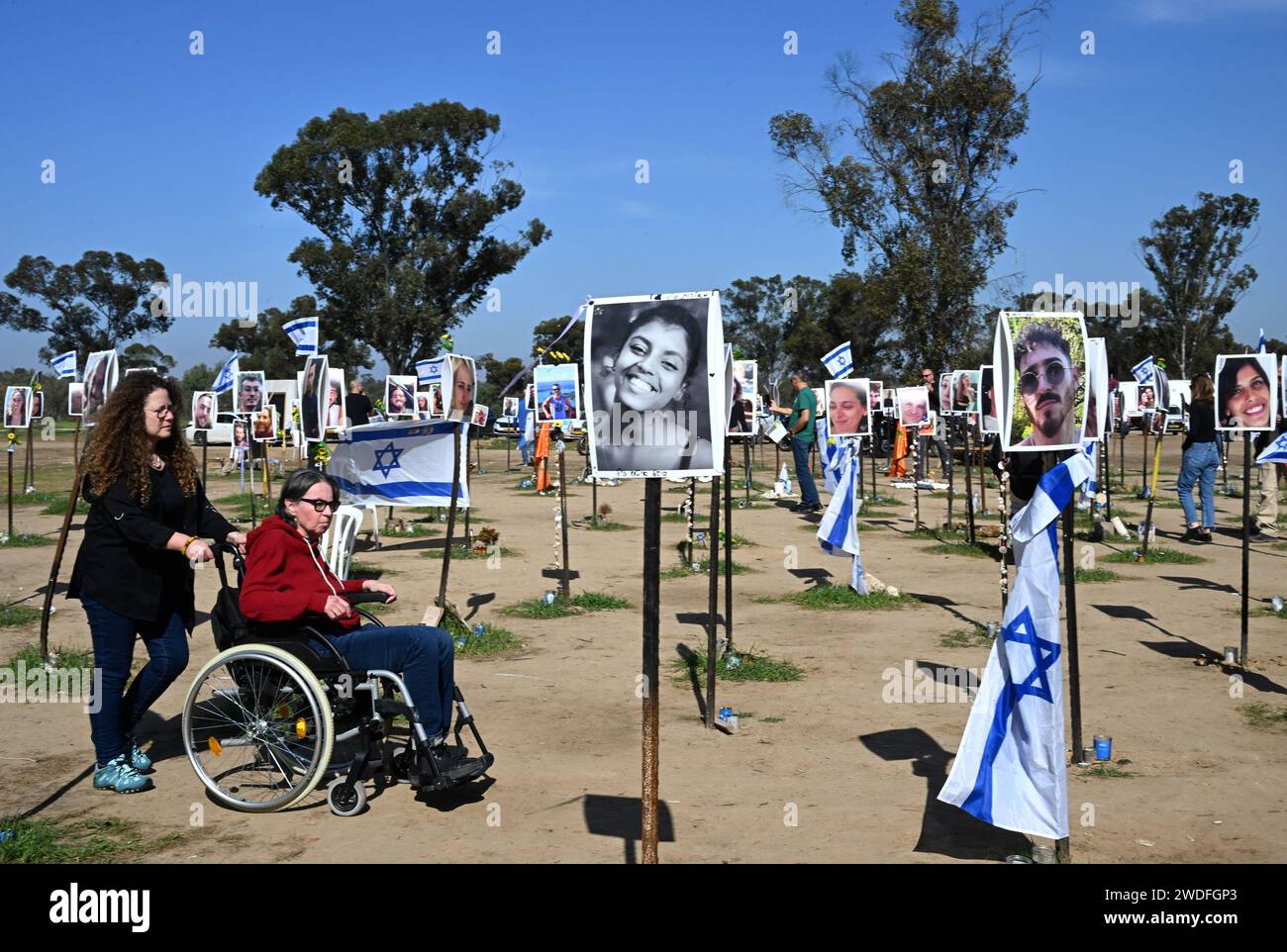 Reim, Israel. 20th Jan, 2024. People walk by national flags and ...