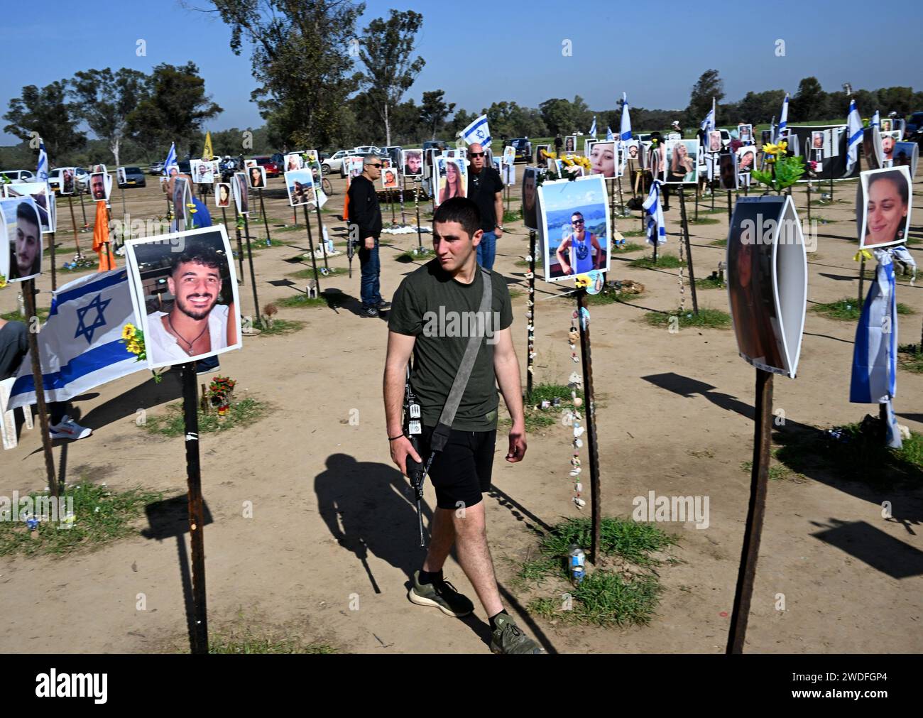 Reim, Israel. 20th Jan, 2024. People walk by national flags and ...