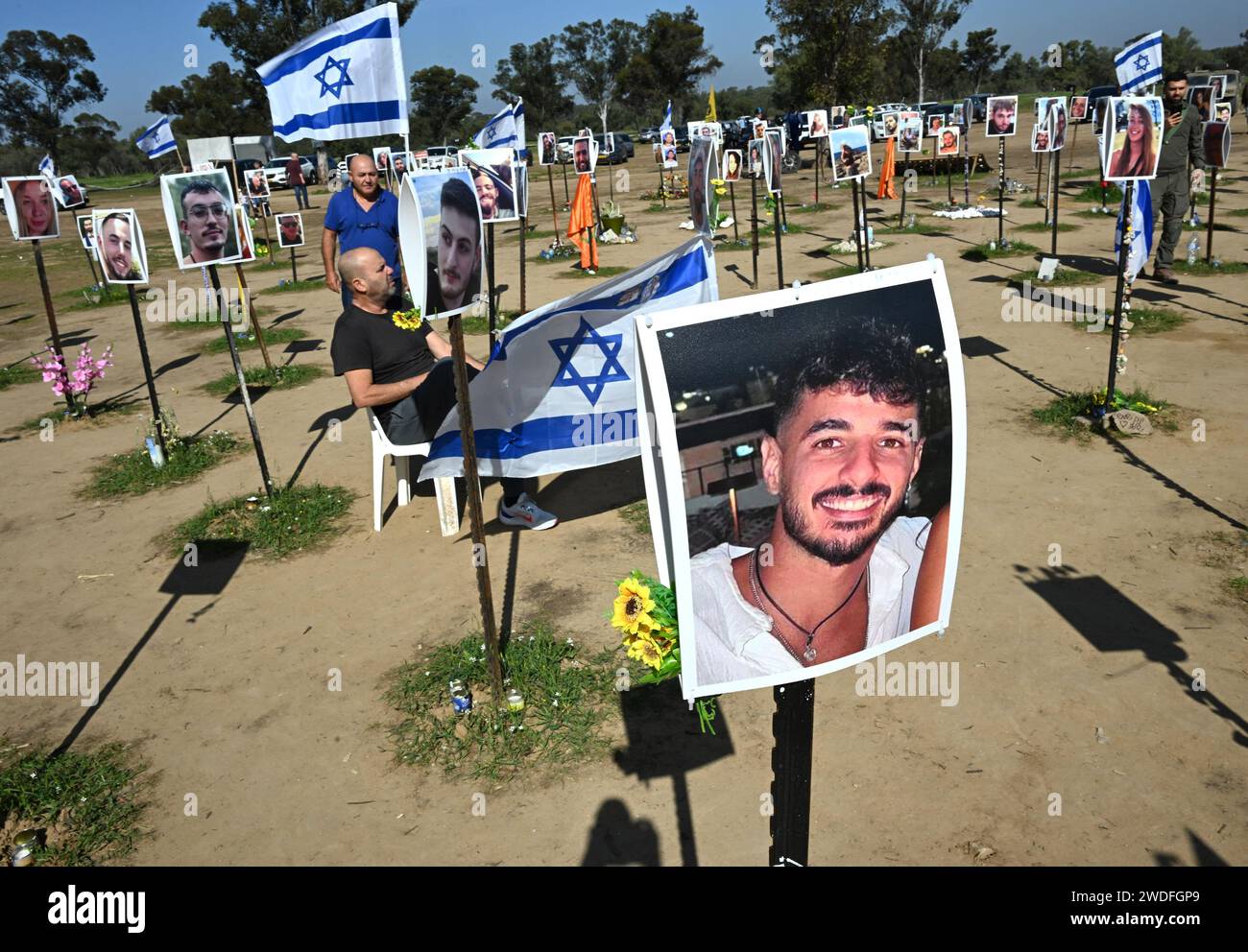Reim, Israel. 20th Jan, 2024. People walk by national flags and ...