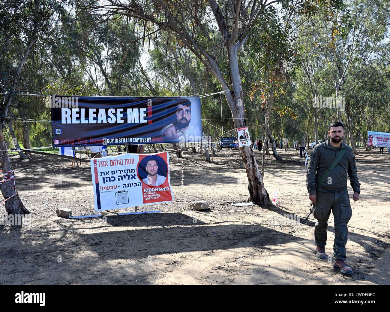 Reim, Israel. 20th Jan, 2024. An Israeli soldier walks past banners ...