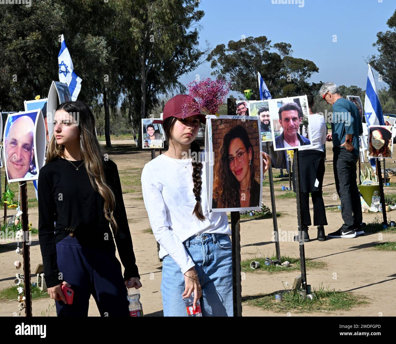 Reim, Israel. 20th Jan, 2024. People walk by national flags and ...