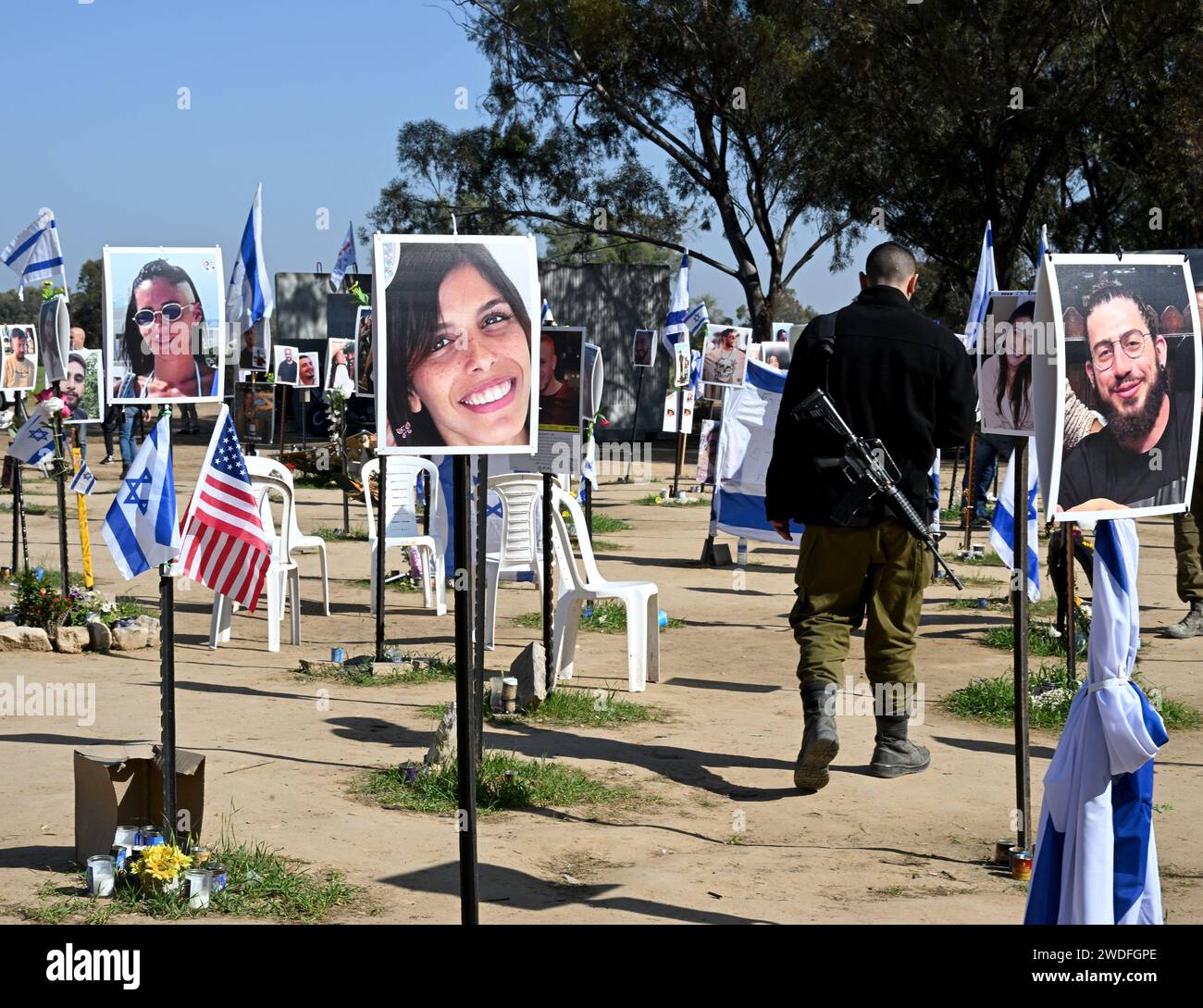 Reim, Israel. 20th Jan, 2024. An Israeli soldier walk by national flags ...