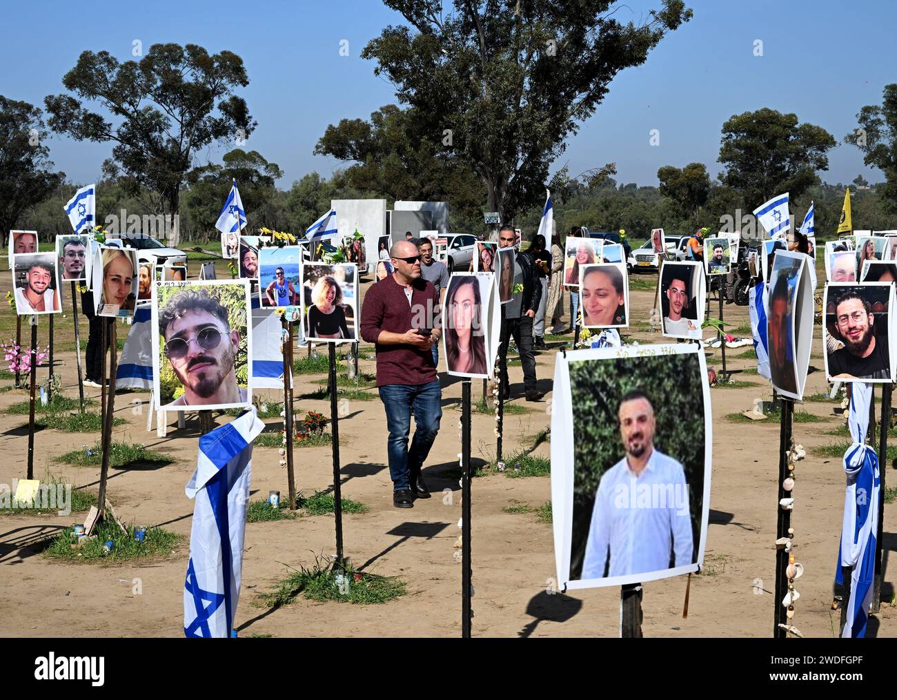 Reim, Israel. 20th Jan, 2024. People walk by national flags and ...