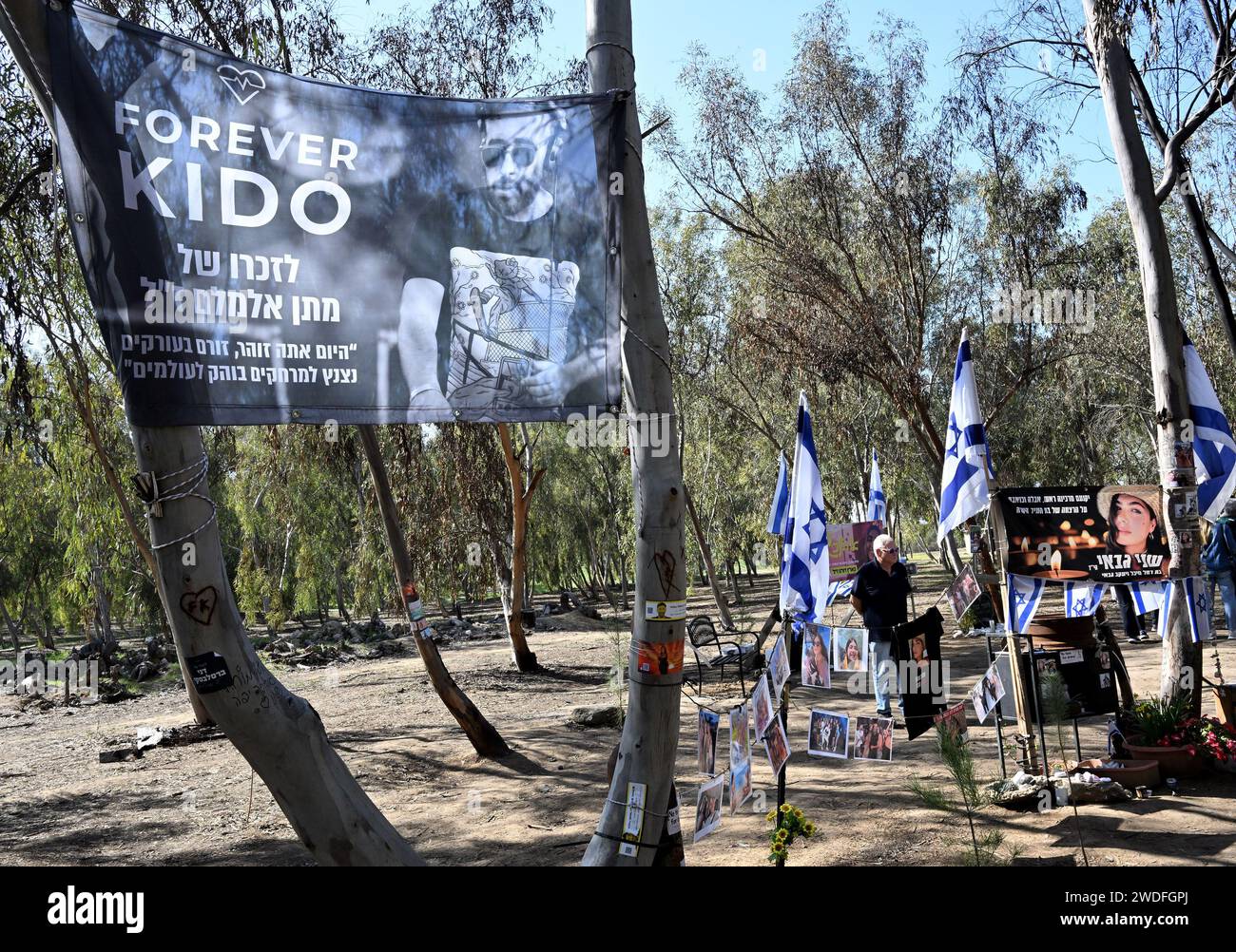 Reim, Israel. 20th Jan, 2024. People walk by national flags and ...