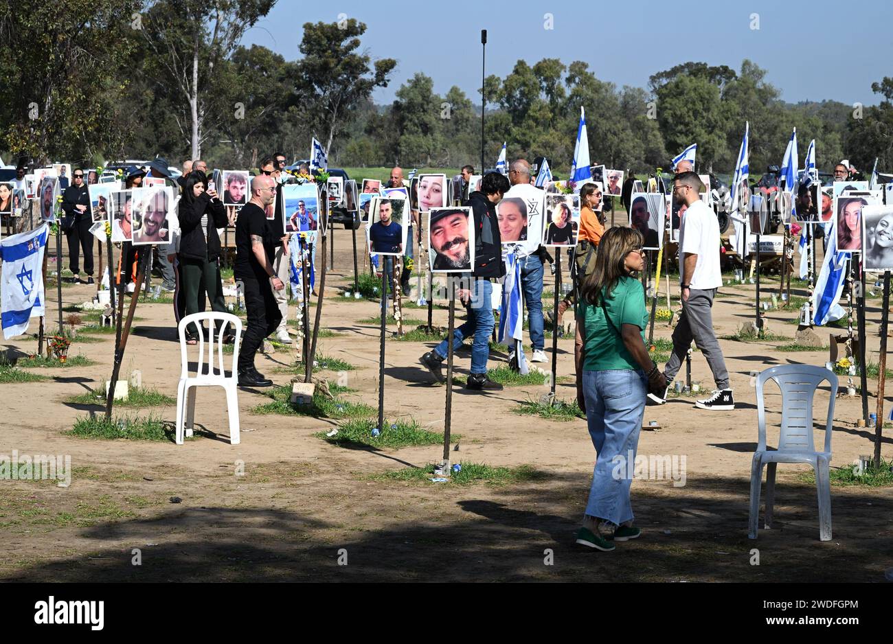 Reim, Israel. 20th Jan, 2024. People walk by national flags and ...