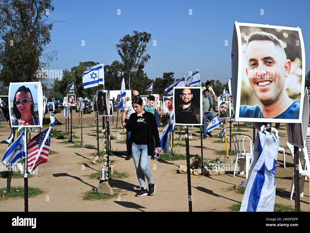 Reim, Israel. 20th Jan, 2024. People walk by national flags and ...