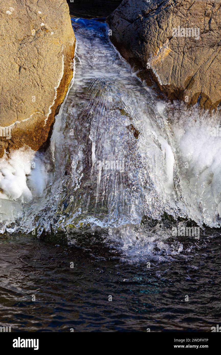 Ice and running water between rocks Stock Photo - Alamy
