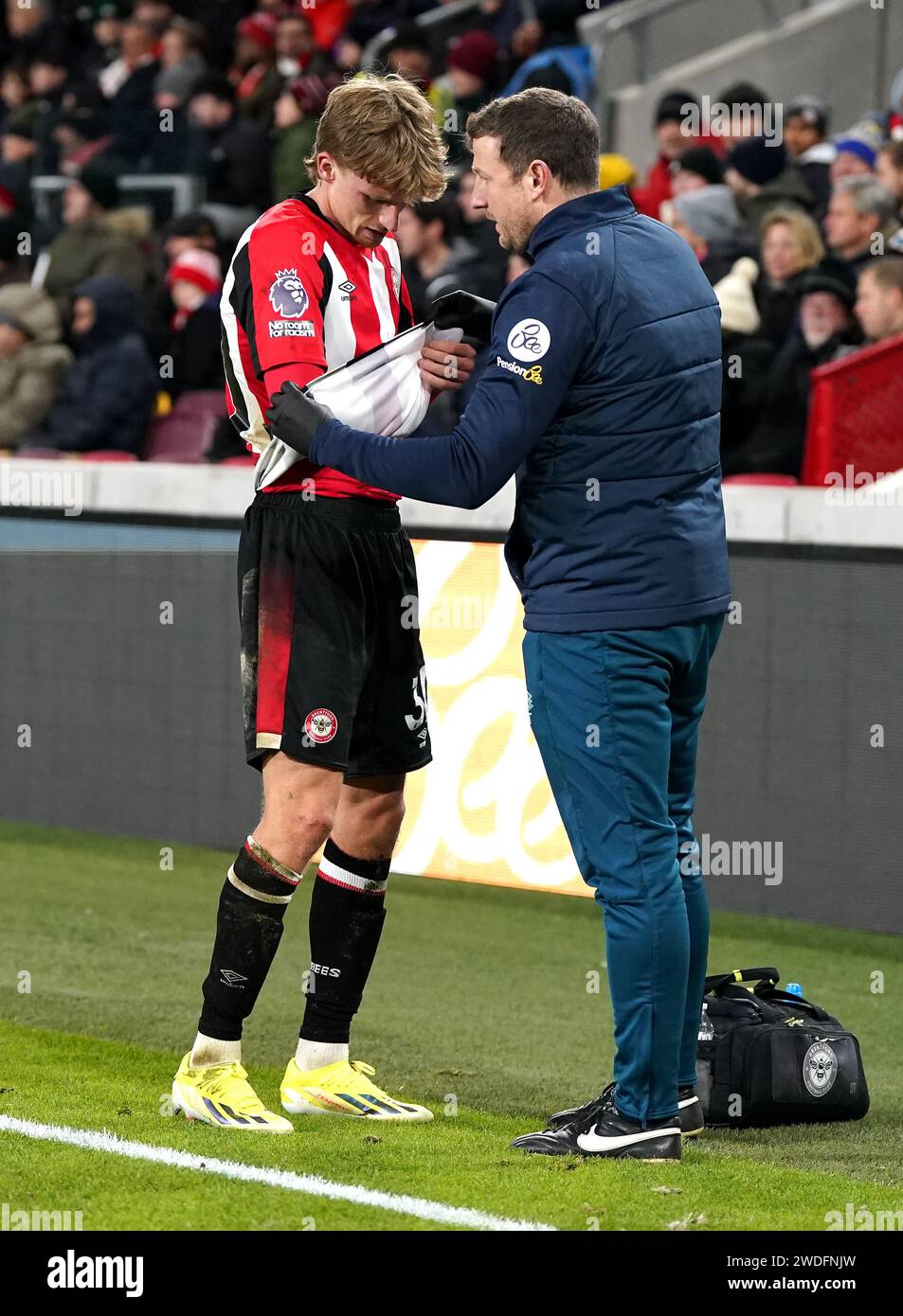 Brentford's Mads Roerslev (left) is treated for an injury by medical ...