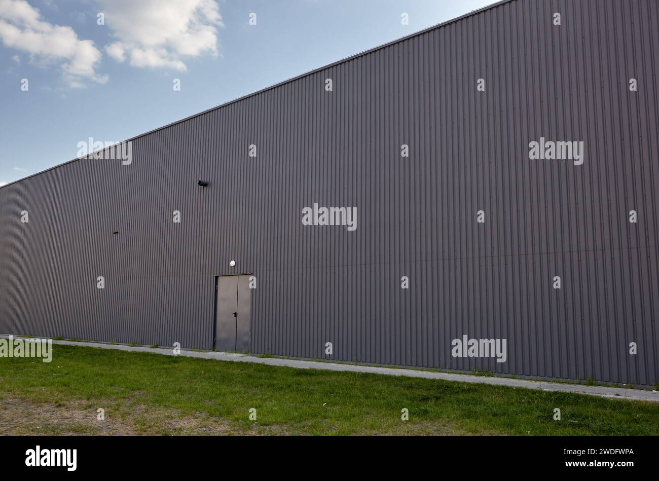 Corrugated steel warehouse or factory industrial building against blue ...