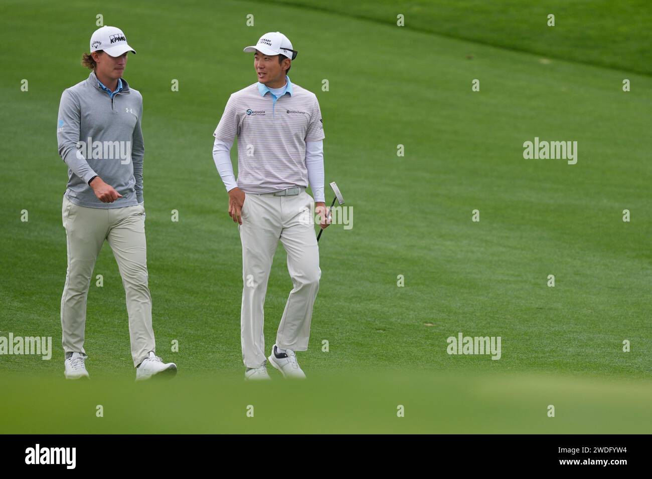 Michael Kim walks with Maverick McNealy on the second fairway on the ...
