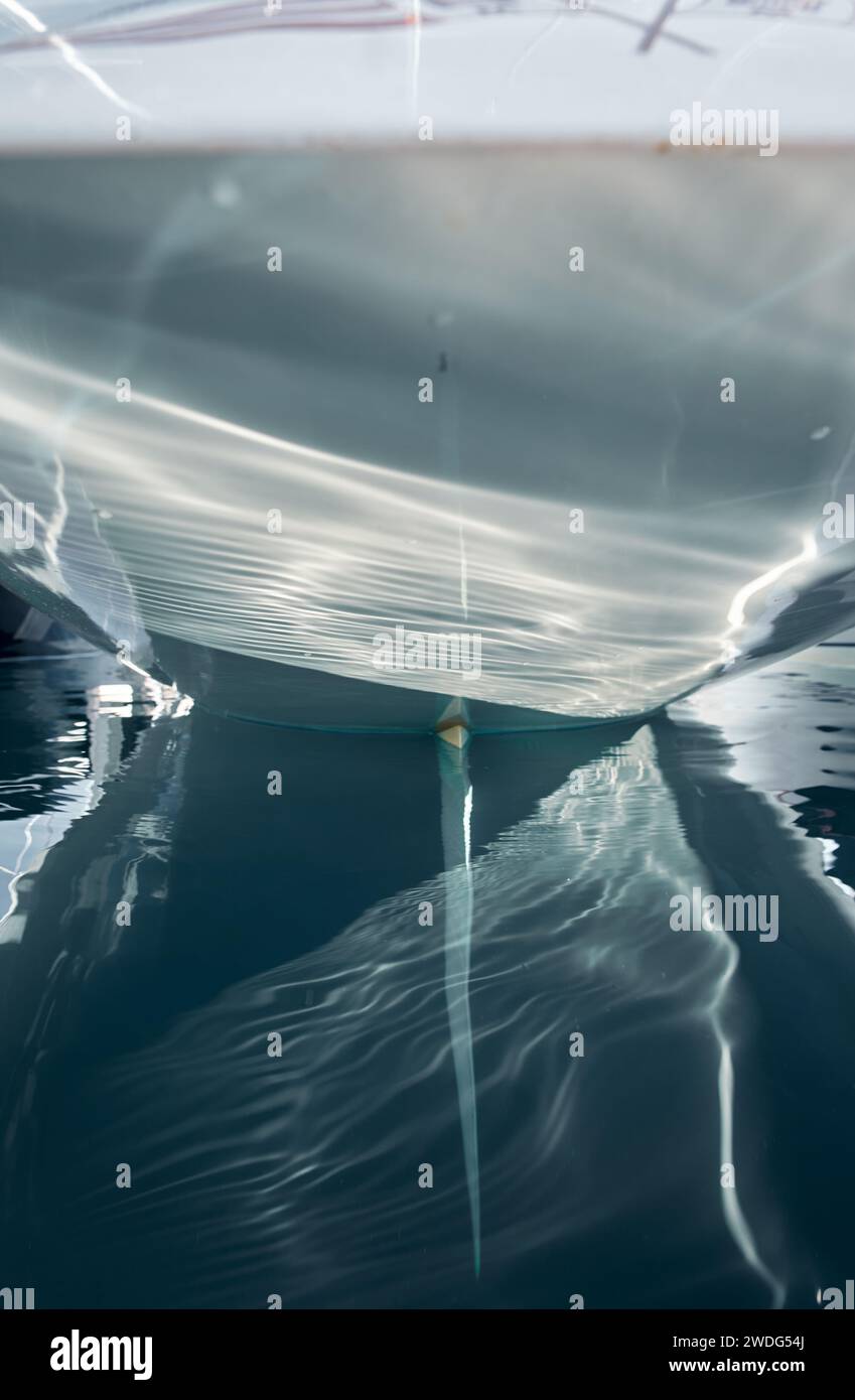 the stern of the sailboat and the rudder feather in the azure water ...