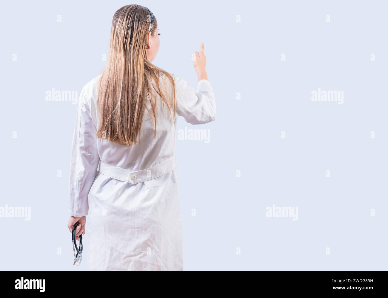 Rear view of female doctor pointing isolated. Young female doctor from ...