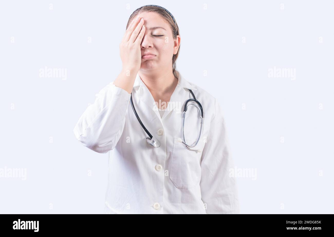 Stressed female doctor with hand on forehead isolated. Exhausted young ...