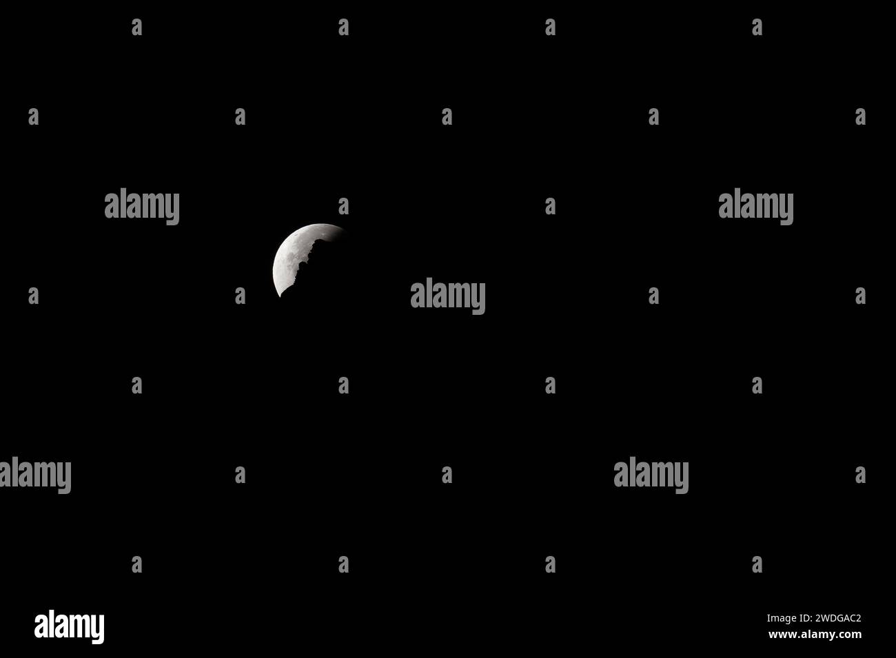 The moon disappears behind a mountain silhouette, taken in the Swiss ...