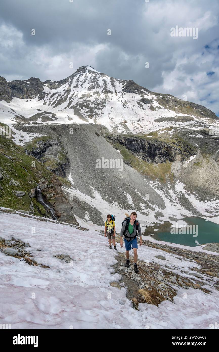 Two mountaineers on a hiking trail with snow, mountain landscape with ...