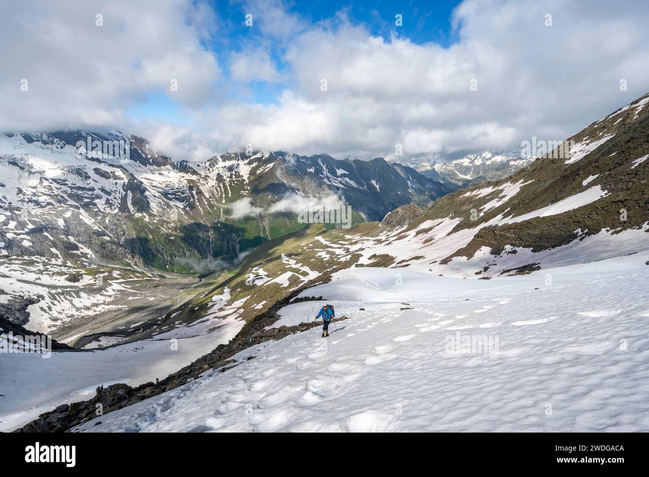 Mountaineer on hiking trail with snow, mountain landscape with summit Hoher Weisszint and ...