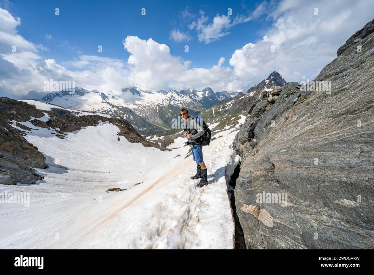 Mountaineer on a hiking trail with snow, ascent to the Nordliche Moerchnerscharte, behind ...