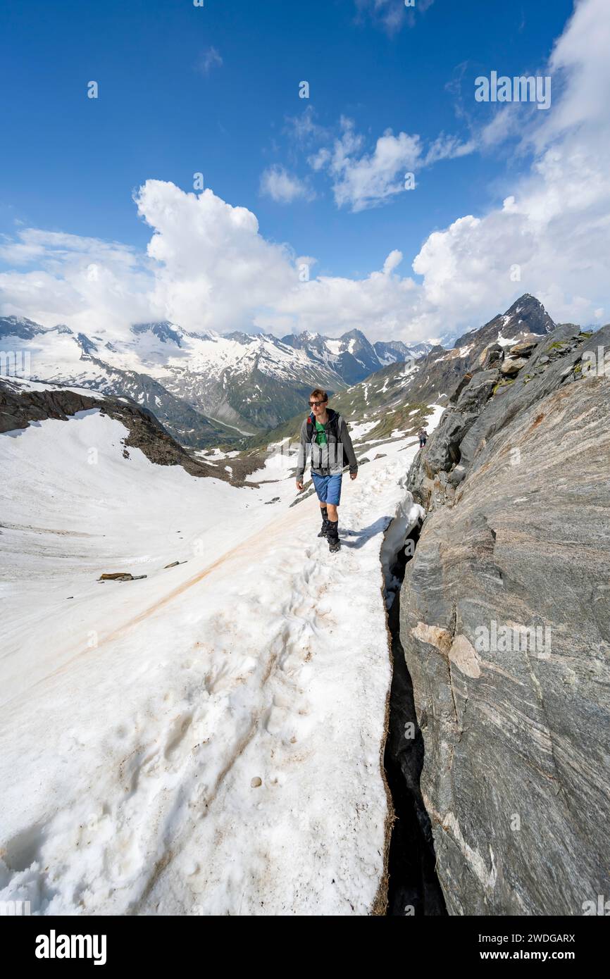 Mountaineer on a hiking trail with snow, ascent to the Nordliche Moerchnerscharte, behind ...