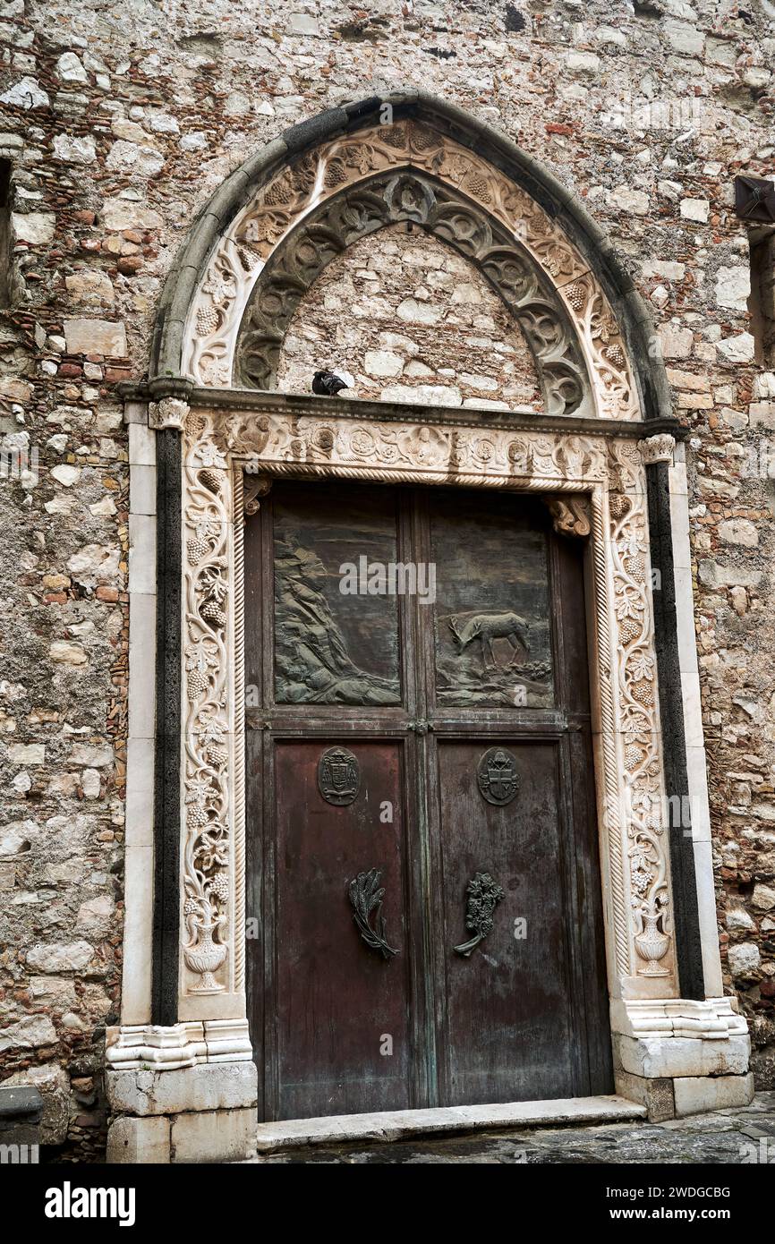 Wooden, decorated door of a medieval stone church in Taormina on the ...