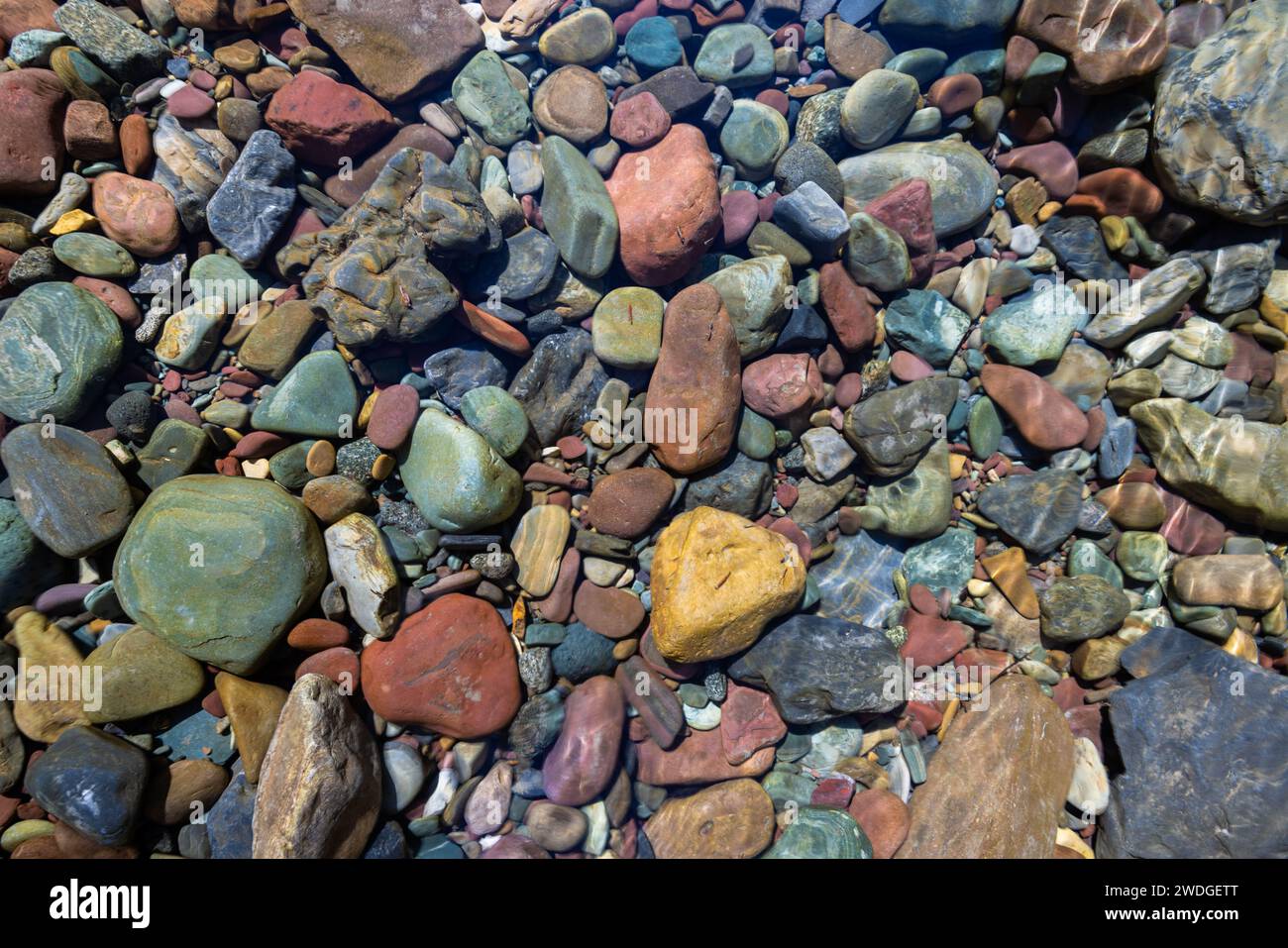 Naturally colorful river rocks under water in Glacier National Park ...