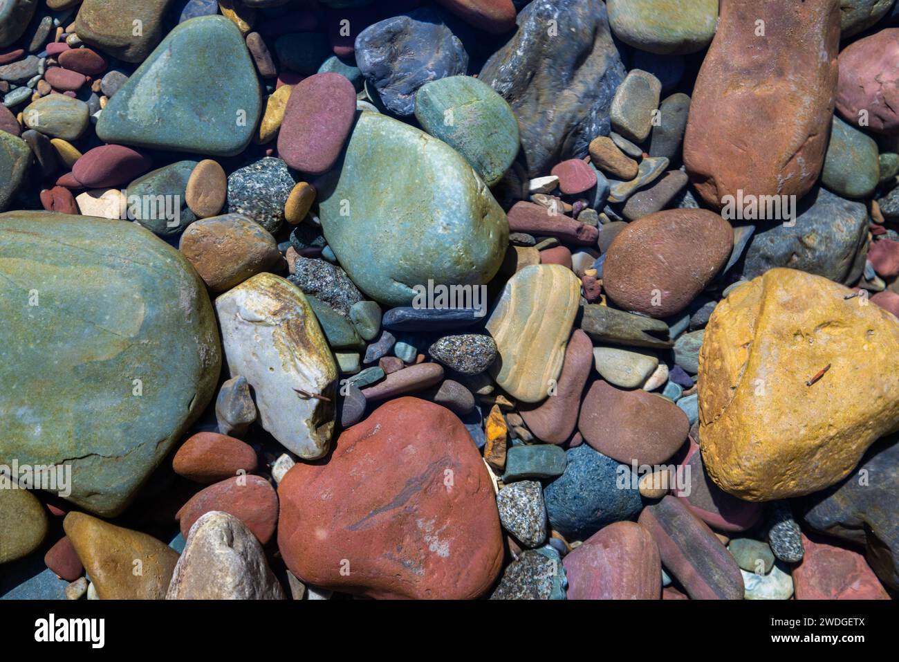 Naturally colorful river rocks under water in Glacier National Park ...
