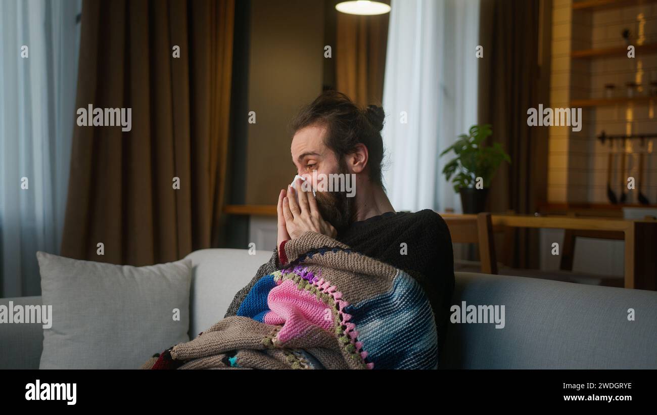 Sick man sneezes on sofa hi-res stock photography and images - Alamy