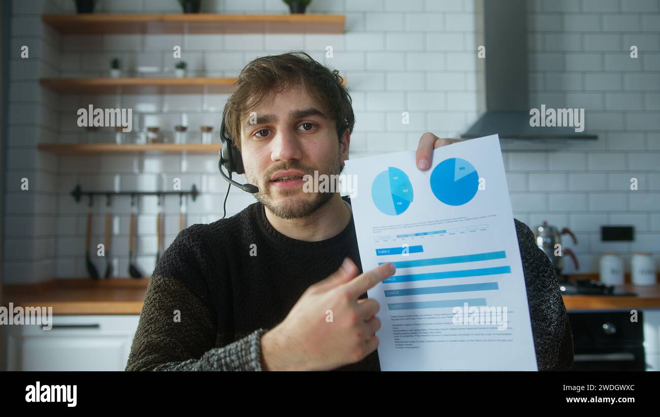 A angry manager man with wireless headset sitting in modern kitchen at ...